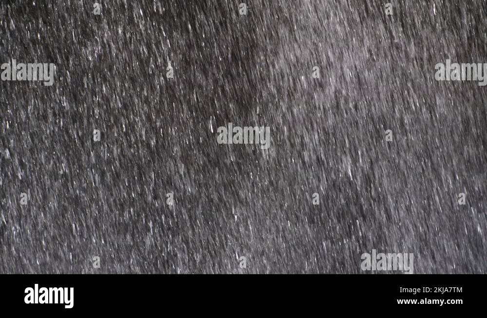 The rapidly falling water forms a wall of water droplets, solid ...