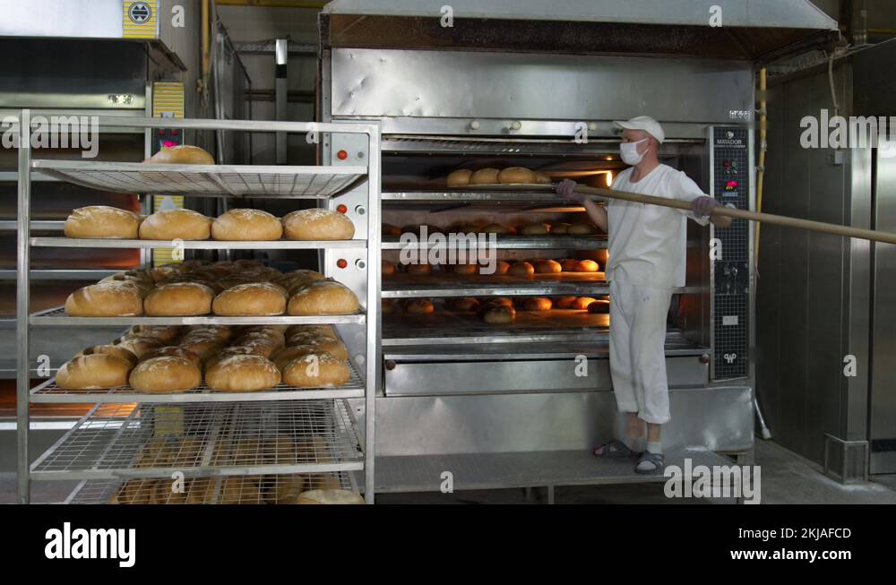 Chef removes freshly baked bakery products from the oven. Baked bread ...