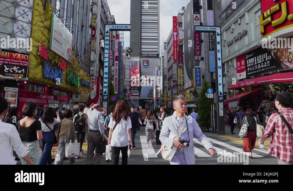 Many japanese people cross a packed road in Shinjuku, Tokyo while rush ...