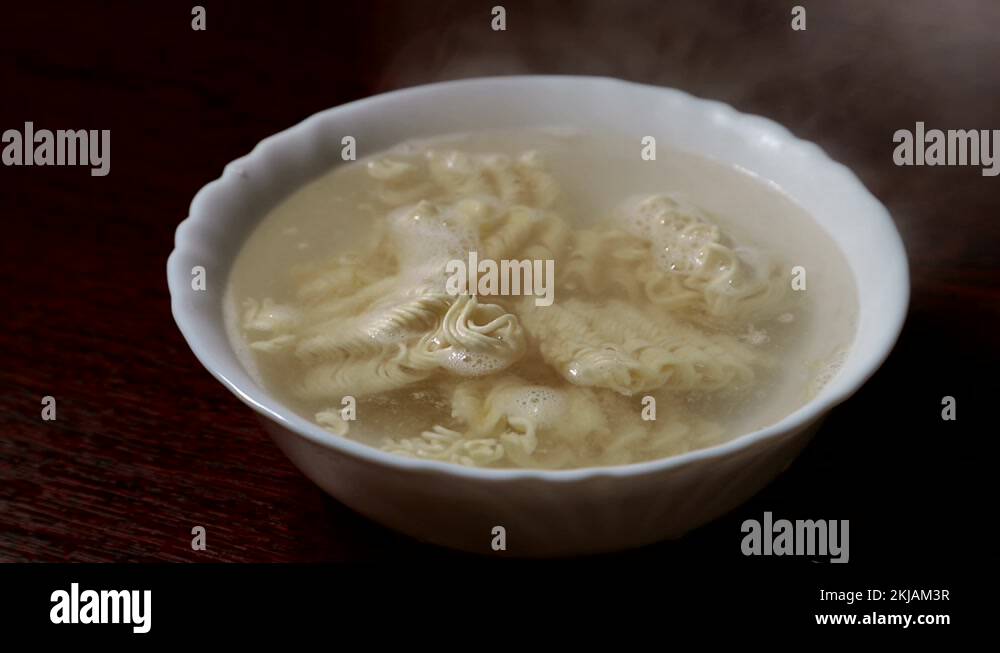 Noodles in boiling water. Man pouring water over instant noodles Stock ...