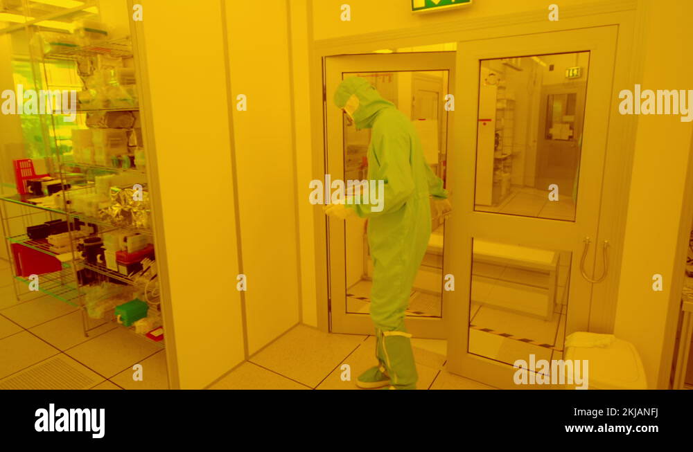 Man in PPE enters biotech research laboratory through heavy safety ...