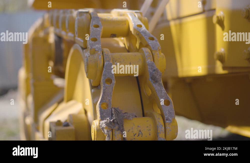 Extreme close-up of yellow tracked tractor. Back view of part of ...