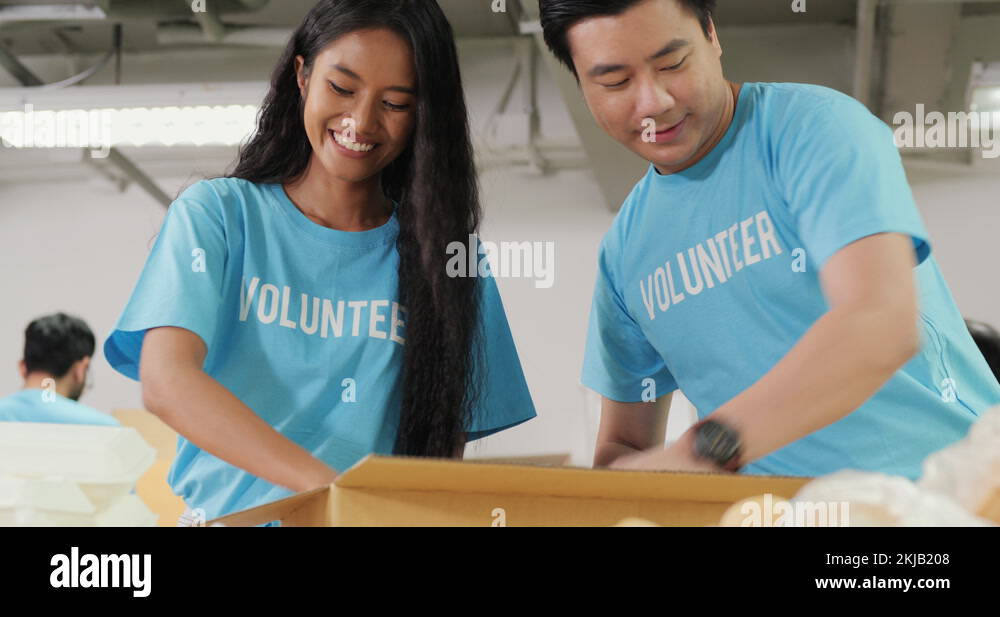 Male and female volunteer preparing free food delivery for poor people ...
