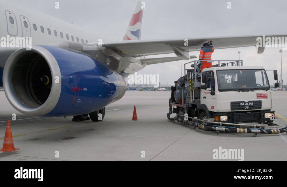 Medium wide shot of a member of the ground crew working under the wing ...