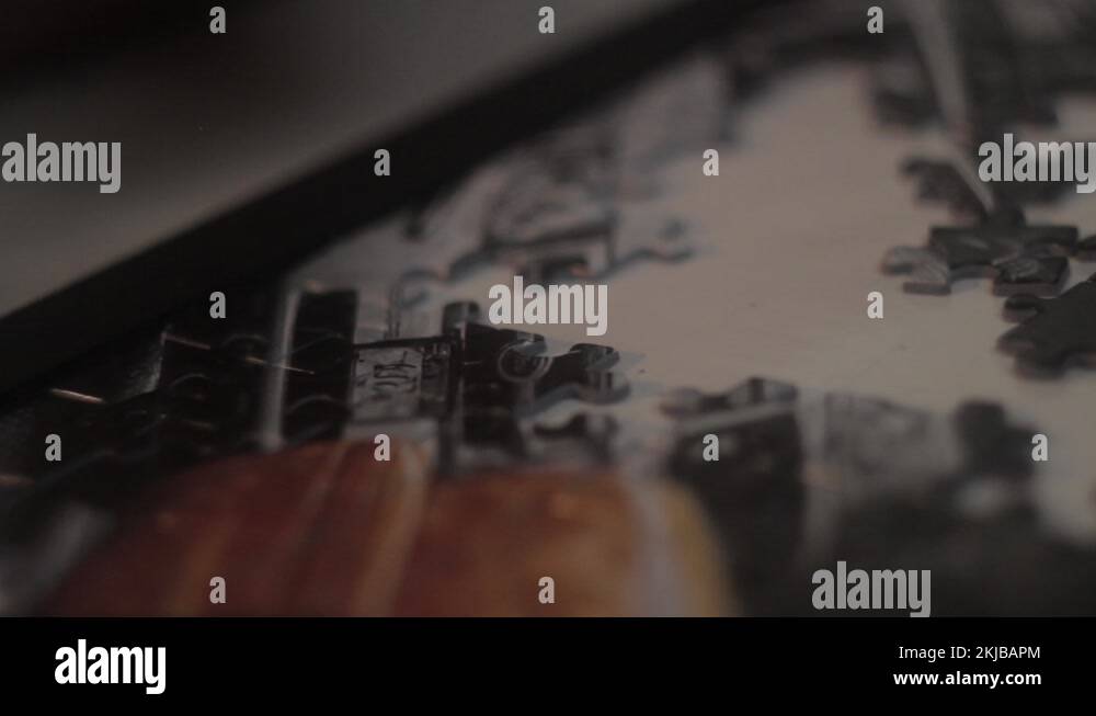 Some footage showing a hand adding a piece to an uncomplete puzzle ...