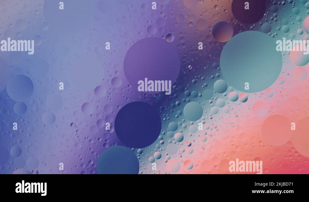 Close-up footage of oil flowing across a water surface with a colourful ...