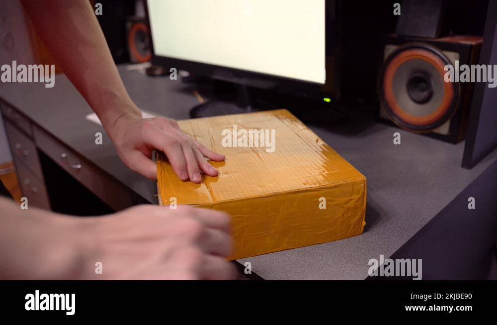 Unpacking cardboard parcel box. Man hands unpacking unboxing new ...