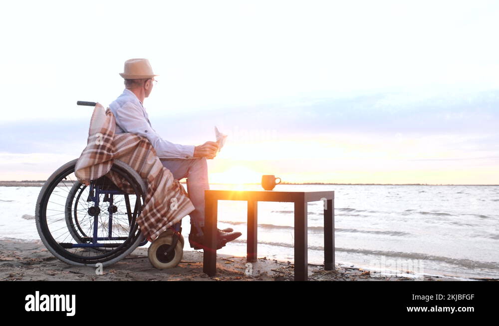 Disabled man, handicapped old grandfather reads newspaper sitting in ...