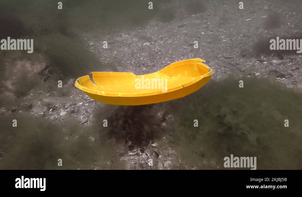 Plastic pollution of the sea: a plastic disposable dish slowly sinks to ...