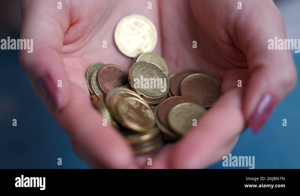 Shaking coins in person's hands, charity donation for low-income ...