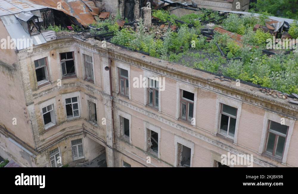 Abandoned old apartment building with broken windows and burnt rooftop ...