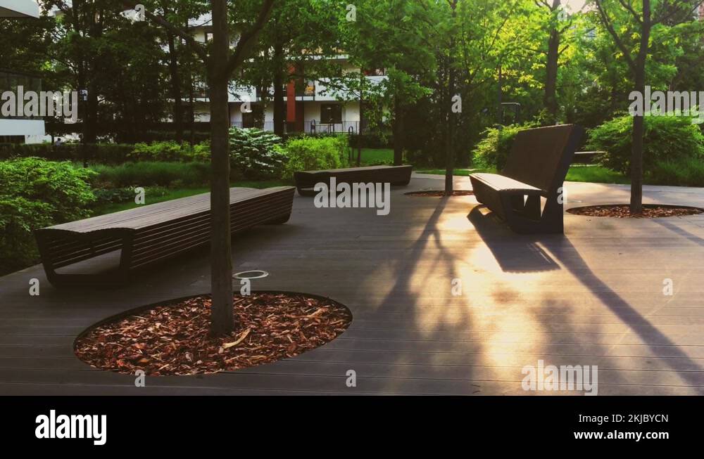 Wooden bench in a modern park at sunset, architecture and outdoor ...