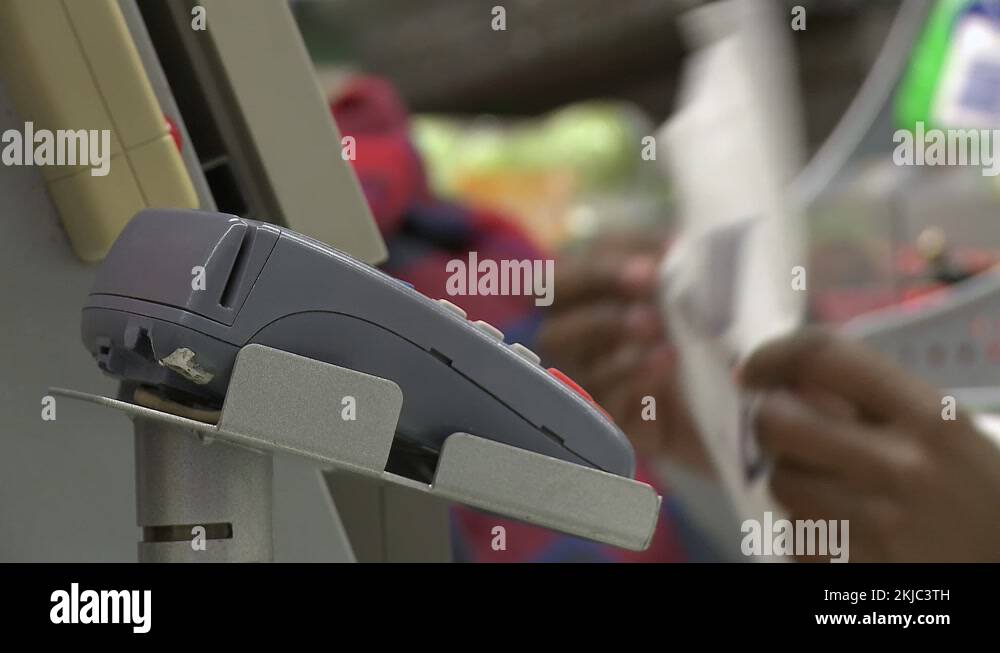 Close up. Supermarket card machine as employee scans groceries and ...