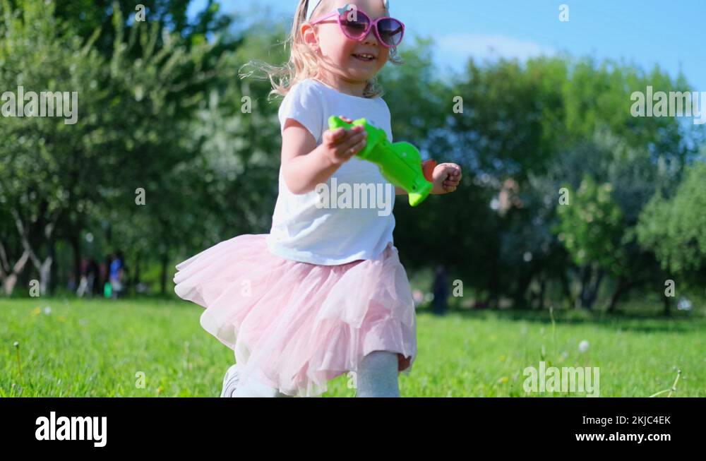 4k. Cute little baby girl running in green park at summer. Happy child ...