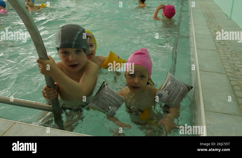 Swimming Practice. Kids learning to swim in swimming pool at ...