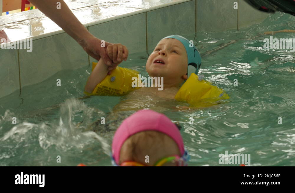 Swimming Practice. Kids learning to swim in swimming pool at ...