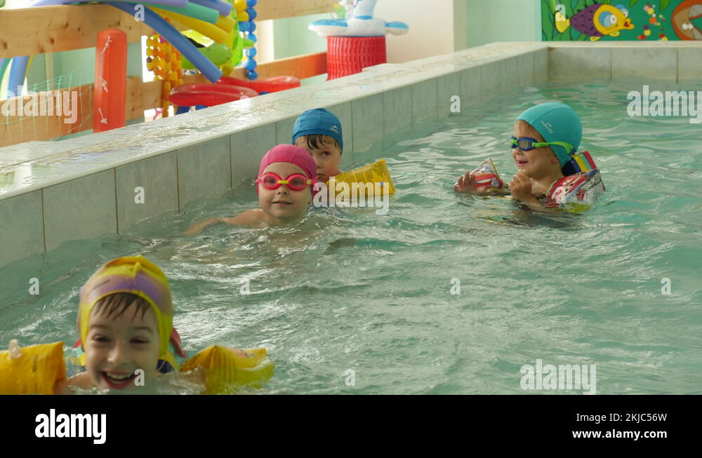 Children swim in the pool. Kids in floating suits learn to swim Stock ...