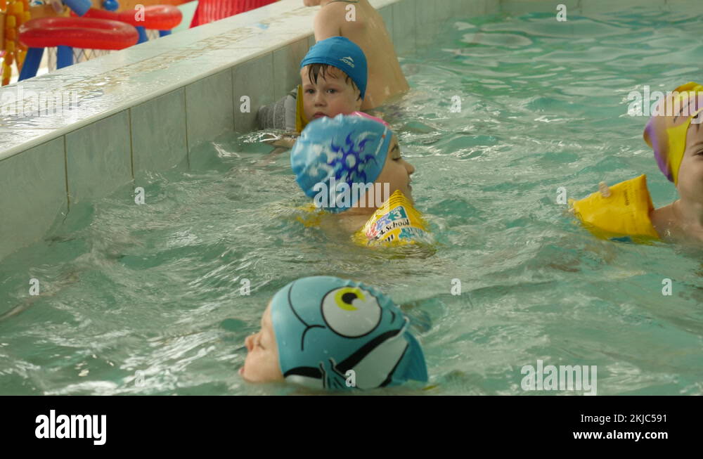 Swimming Practice. Kids learning to swim in swimming pool at ...