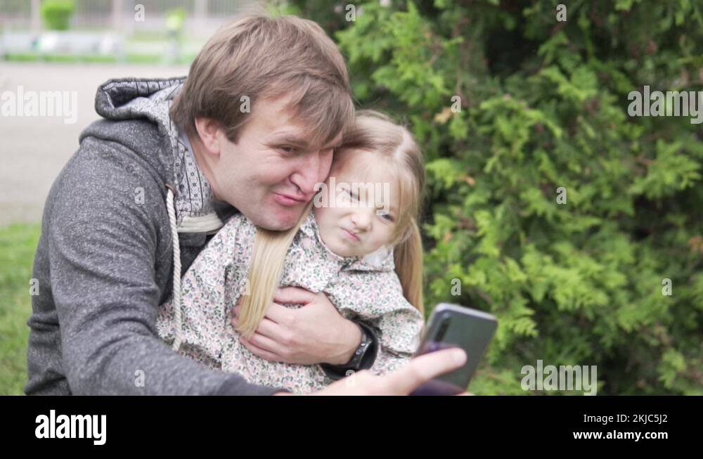 Dad takes a selfie photo on a mobile phone with a beautiful little ...