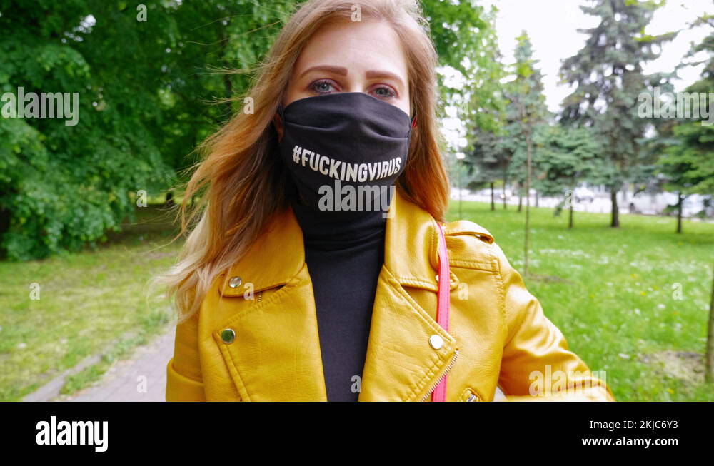 Woman takes off a black mask, closes the camera lens with hand in a ...