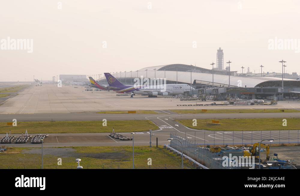 Airliners parked along passenger terminal building, one plane move back ...