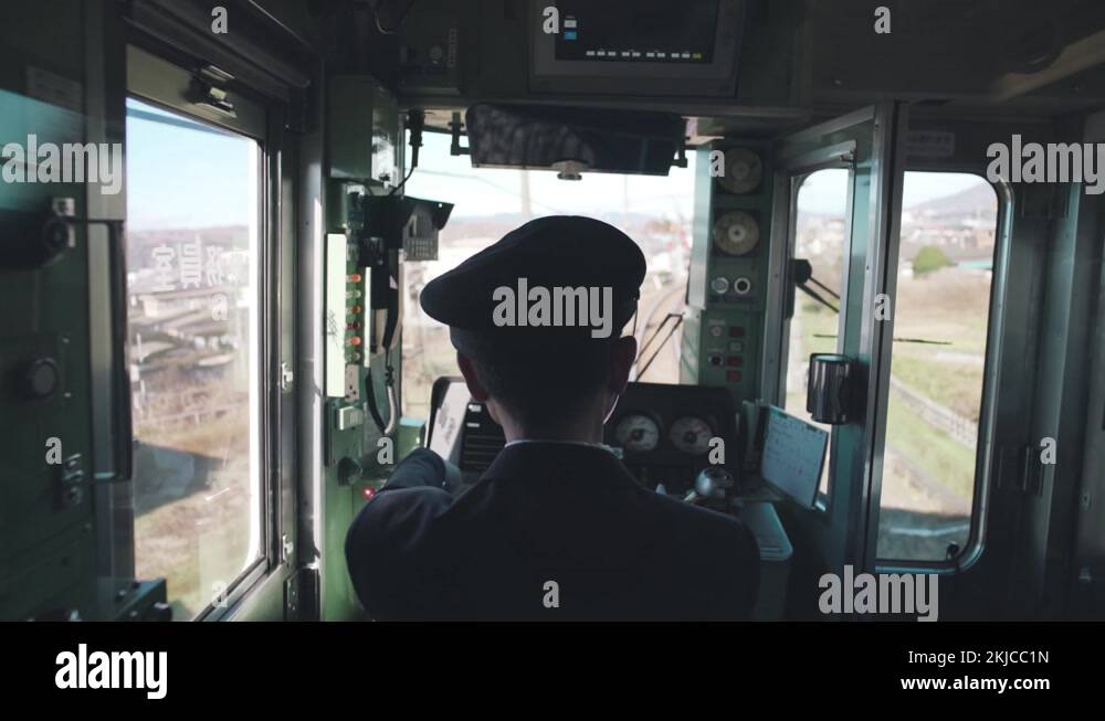 Back View Of A Japanese Train Driver Driving Train In The Cockpit. POV ...