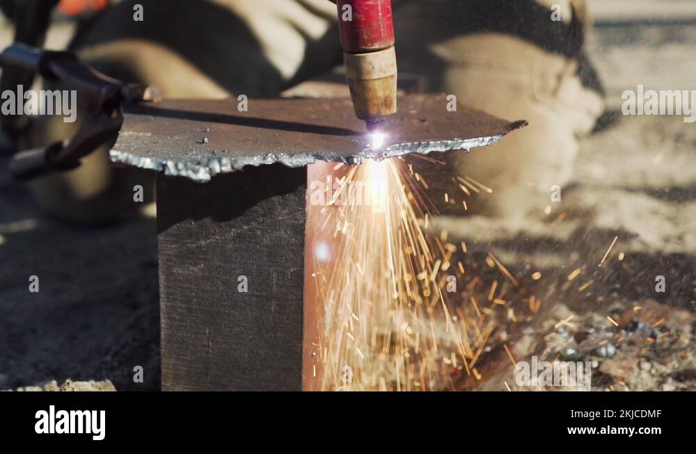 A Blacksmith Man Cutting A Piece Of Scrap Metal Plate Using A Cutting ...