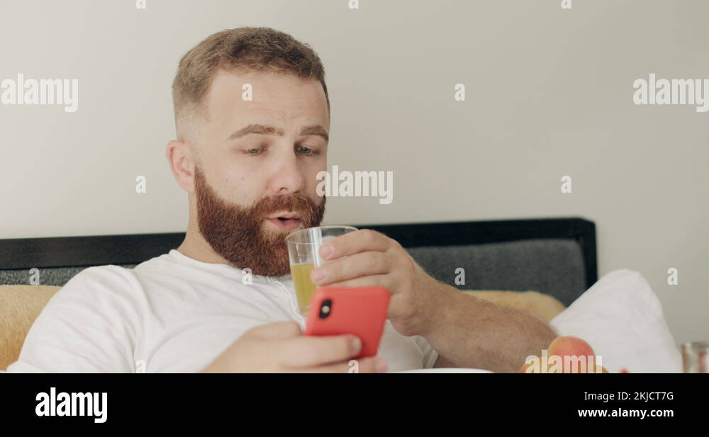 Close up of man in 30s with big eyes choking on juice while looking ...