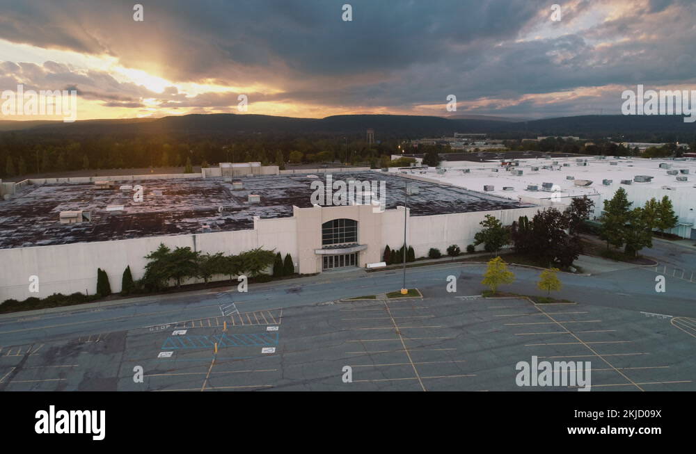 Drone shot abandoned shopping mall with empty parking lot. Death of ...