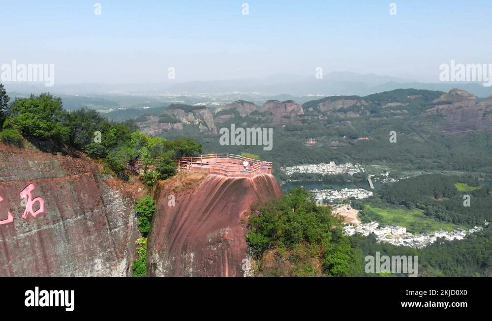 Drone reveal of tourists on the top of a cliff in China, overlooking a ...