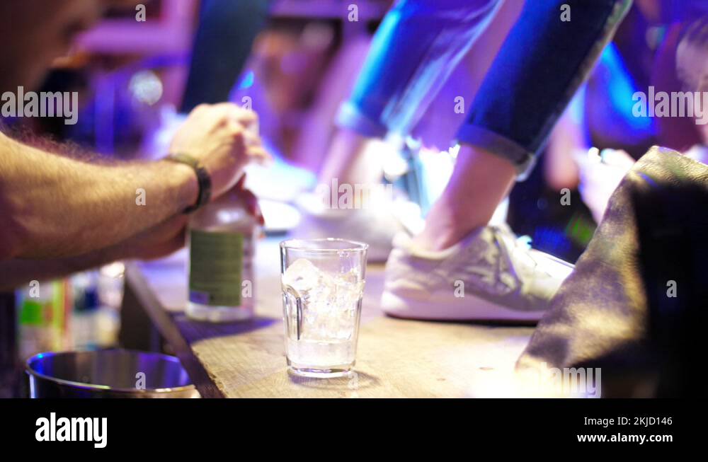 Legs of woman in jeans and sneakers dancing on the bar counter in night ...