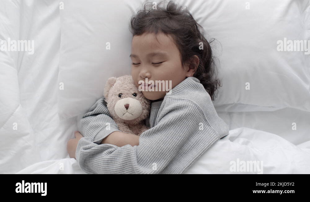 Asian little girl sleeping and hug teddy bear in the bedroom Stock ...