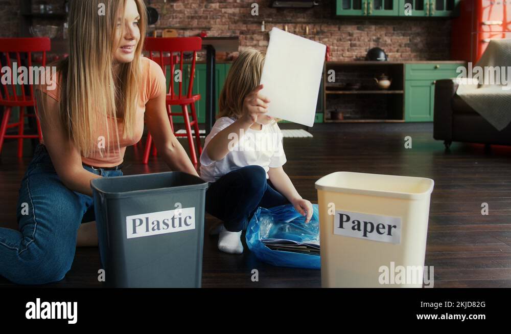Gorgeous mom helping her kid boy to sorting home garbage for recycling paper Stock Video Footage ...