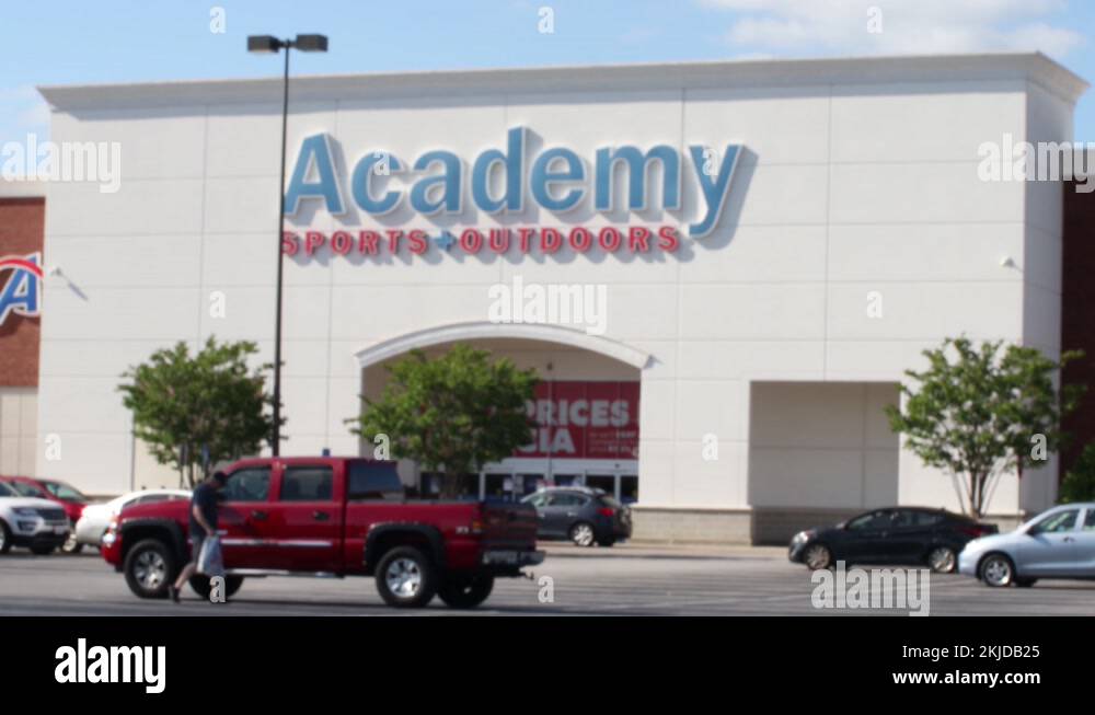 Academy sports retail store building and sign man putting shopping bag ...