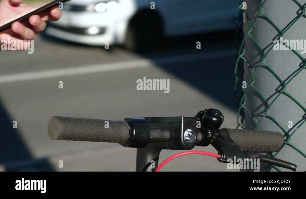Close up man scans barcode or QR code on an electric scooter in app to ...