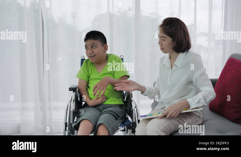 Mother and son with disability in a wheelchair clapping hands to ...