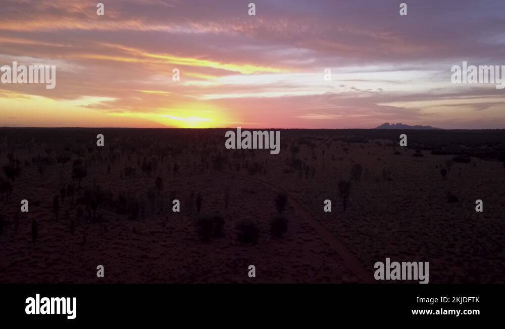 Golden sunset Australian outback, panning right to reveal Uluru/ Ayers ...