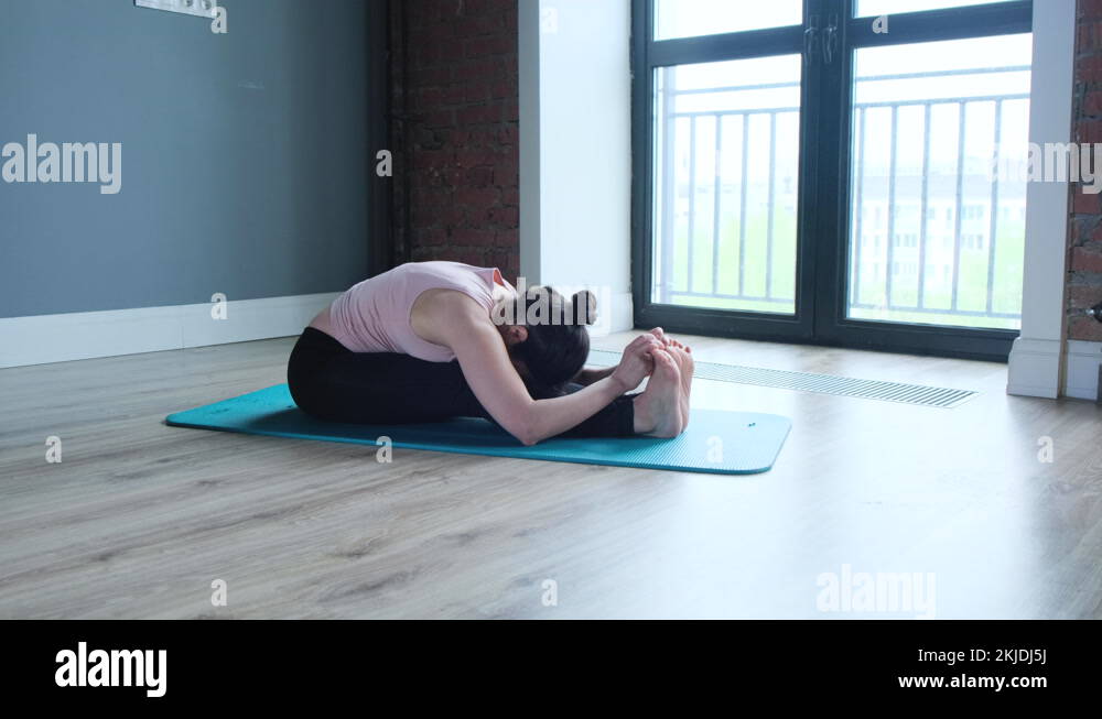 Attractive Indian woman doing yoga exercises to strengthen her back ...