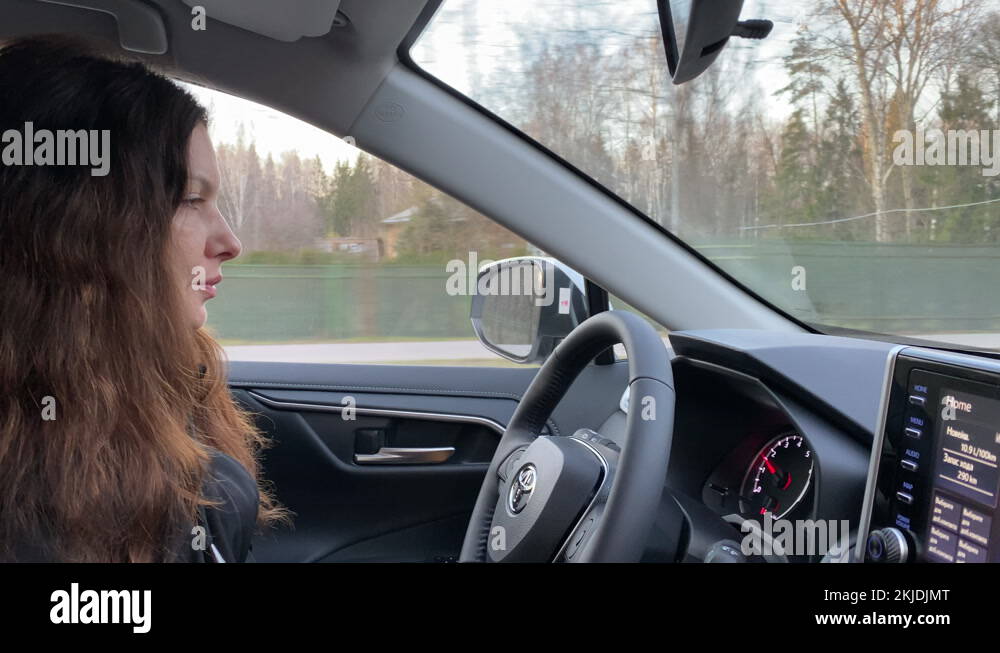 Female driver driving her car, woman behind the wheel Toyota RAV4 ...