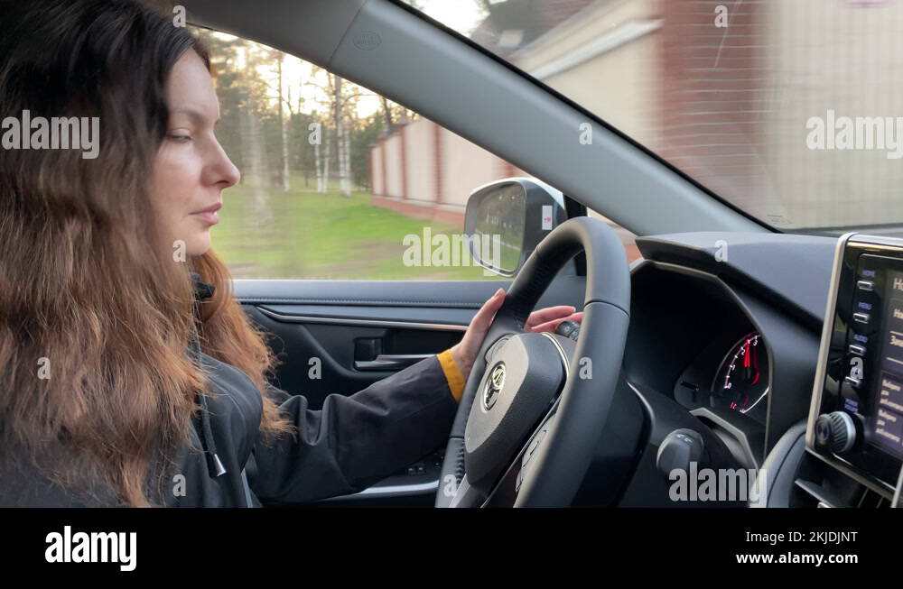 Female driver driving her car, woman behind the wheel Toyota RAV4 ...