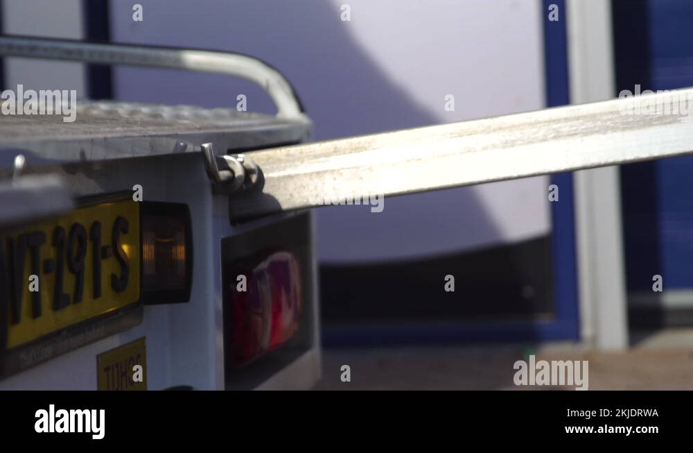 Worker gliding a ramp back inside car trailer, roadside service for ...