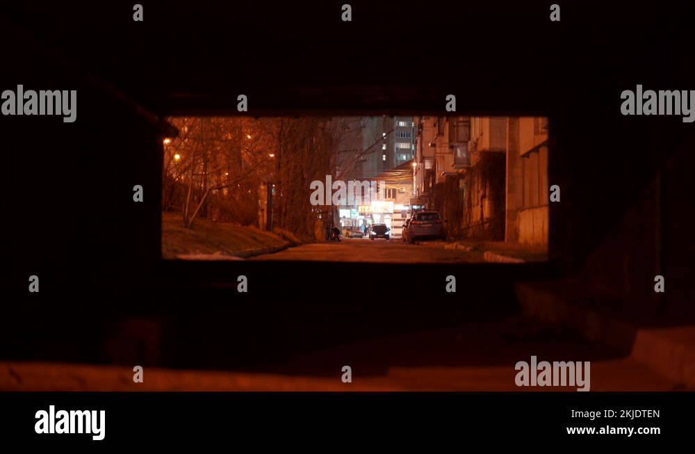 Dark stone gateway with glowing street light at the end of tunnel at ...