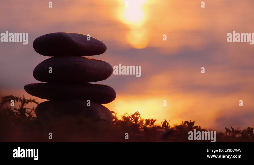 Carefully and intently build a pebble tower. Accuracy and balance ...