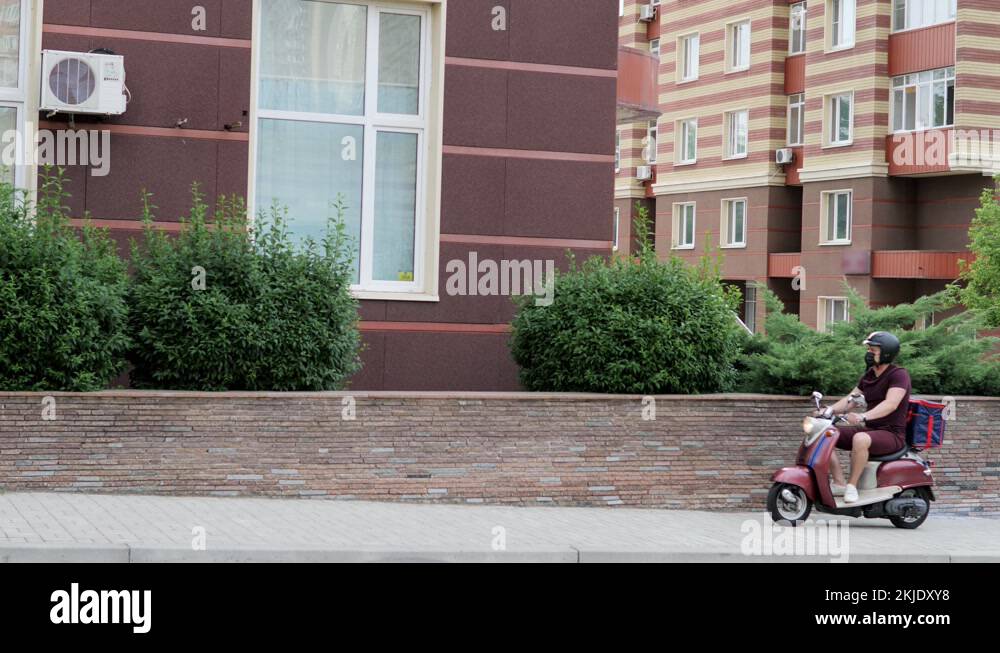 Two girls pick up delivery food box from delivery rider with scooter in ...