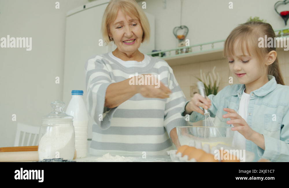 Happy family little child and loving granny cooking in kitchen in ...