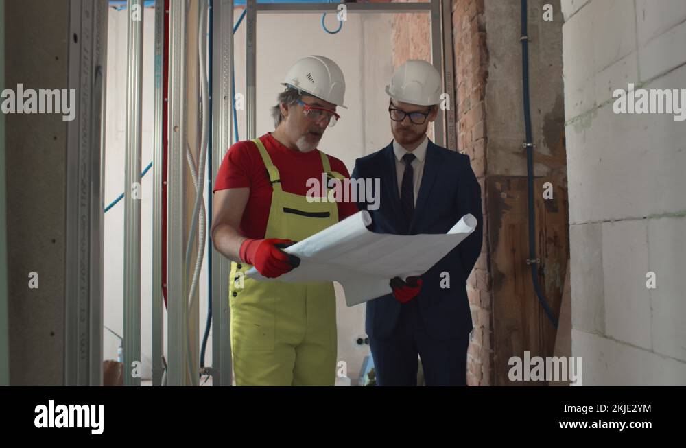 Foreman shows house design plans to businessman at construction site ...