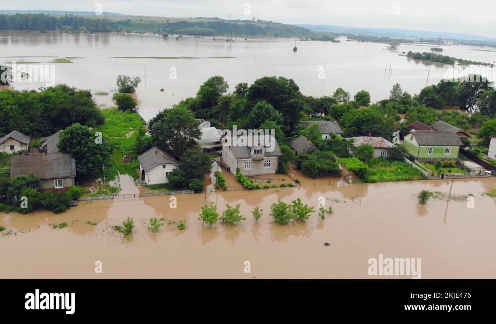 People who are in a flooded house by a river that overflowed after rain ...
