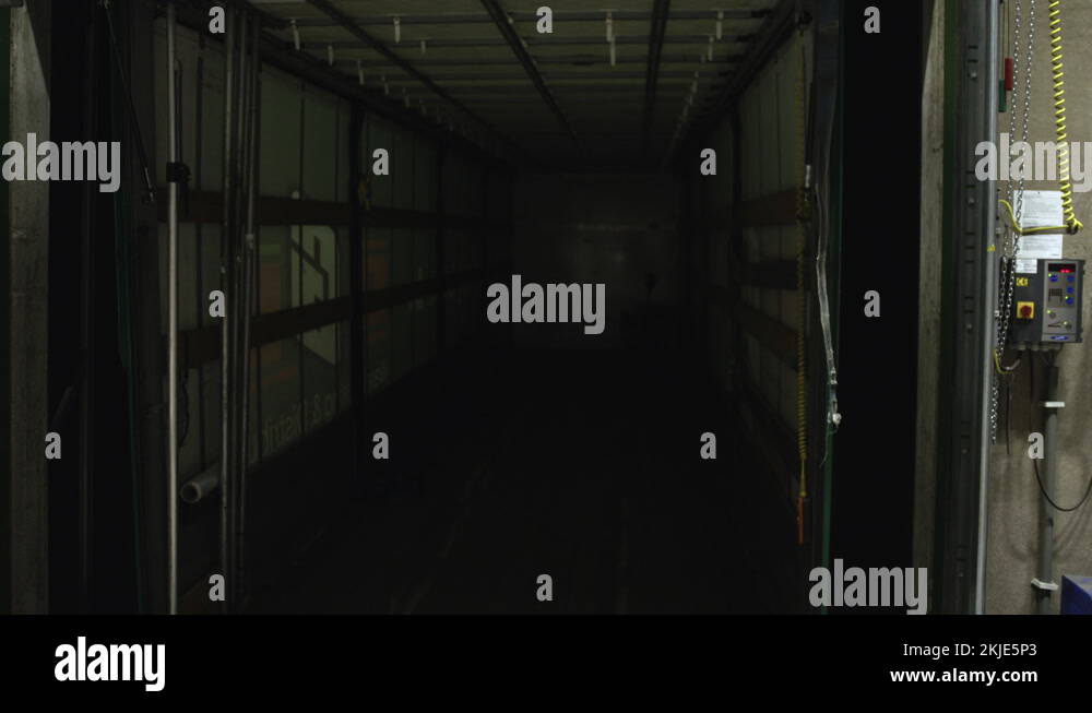 Lights turning on inside empty truck, lorry parked in warehouse dock ...