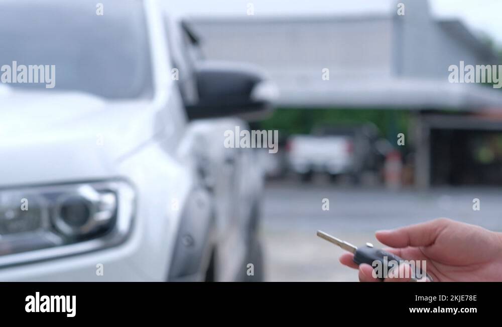 Man asia opens his car using control remote key pressing button on ...