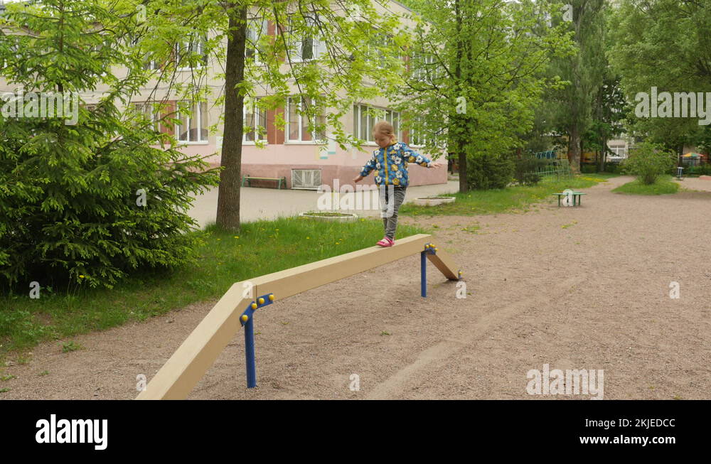 Little girl walking on playground. Kid walking and playing at ...
